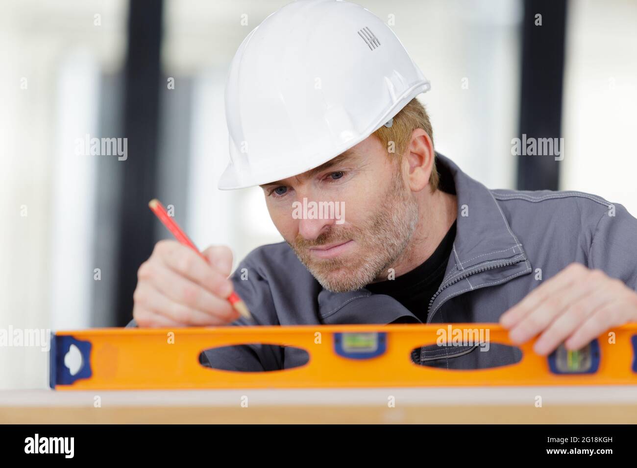 a builder using spirit level Stock Photo - Alamy