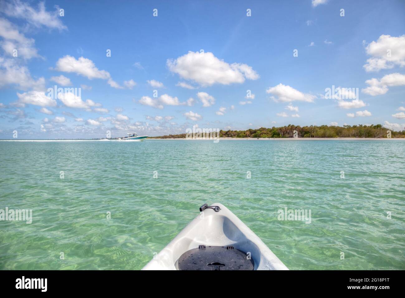 Speed boat in front of Kayak on crystal clear ocean water of Delnor ...