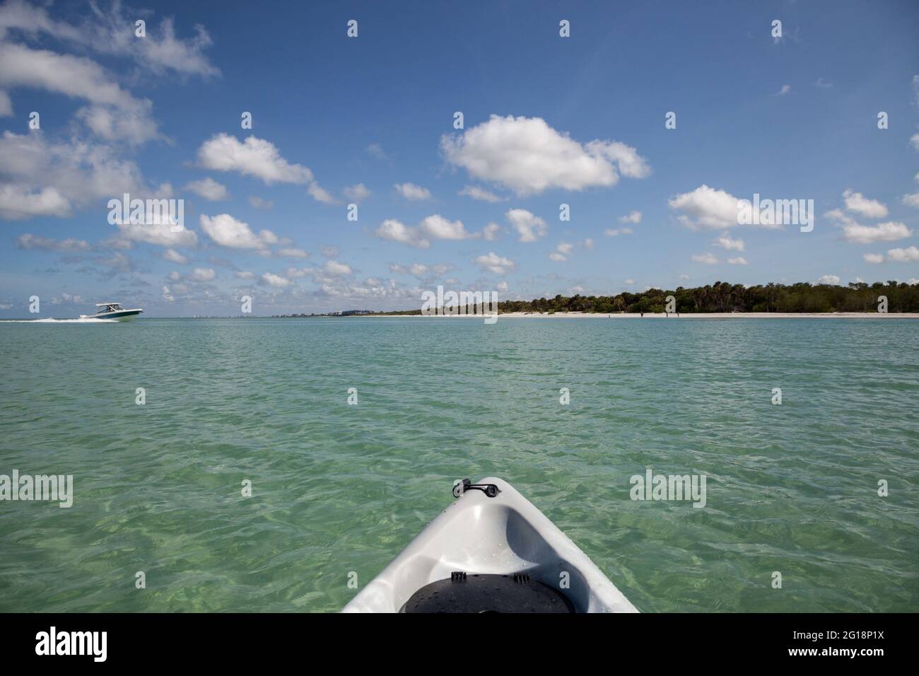 Speed boat in front of Kayak on crystal clear ocean water of Delnor ...