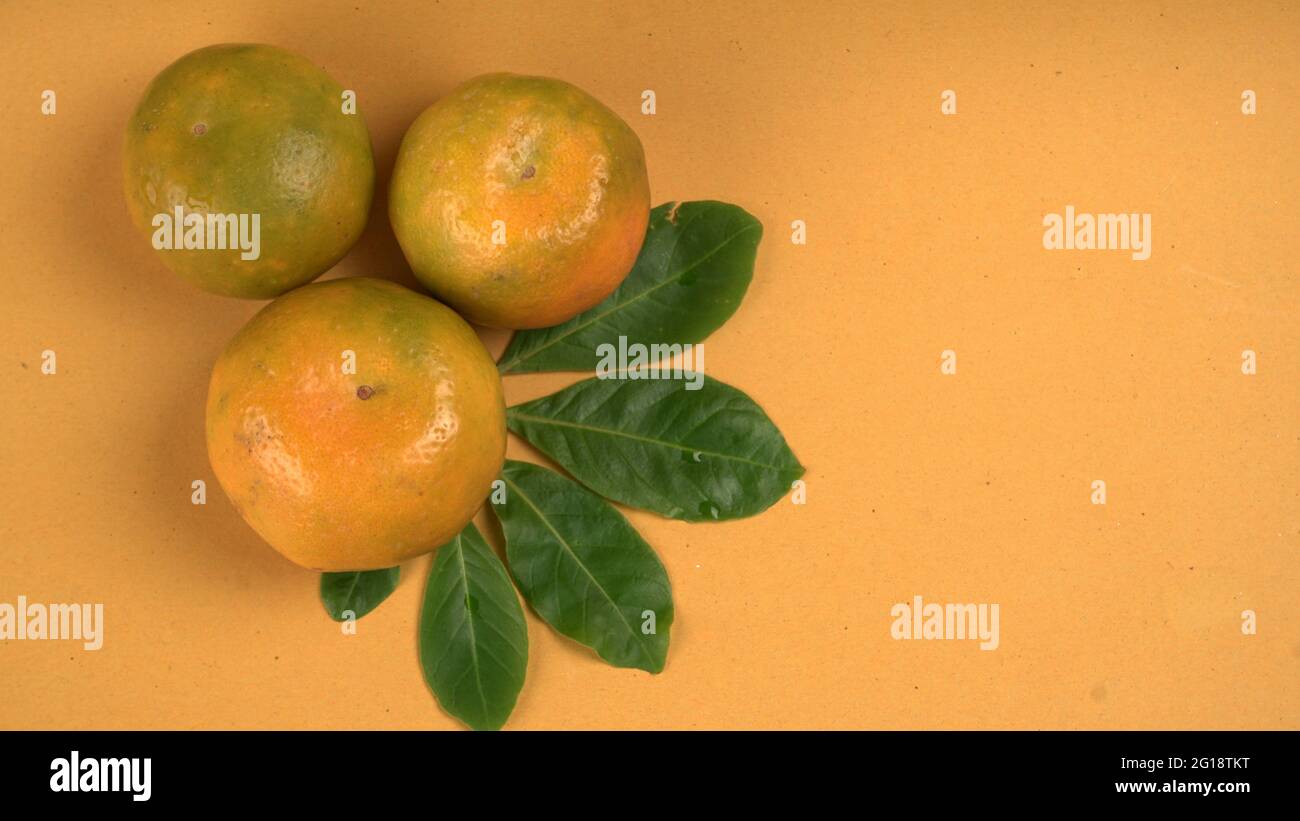 Fresh orange citrus fruit with leaves isolated on yellow background ...