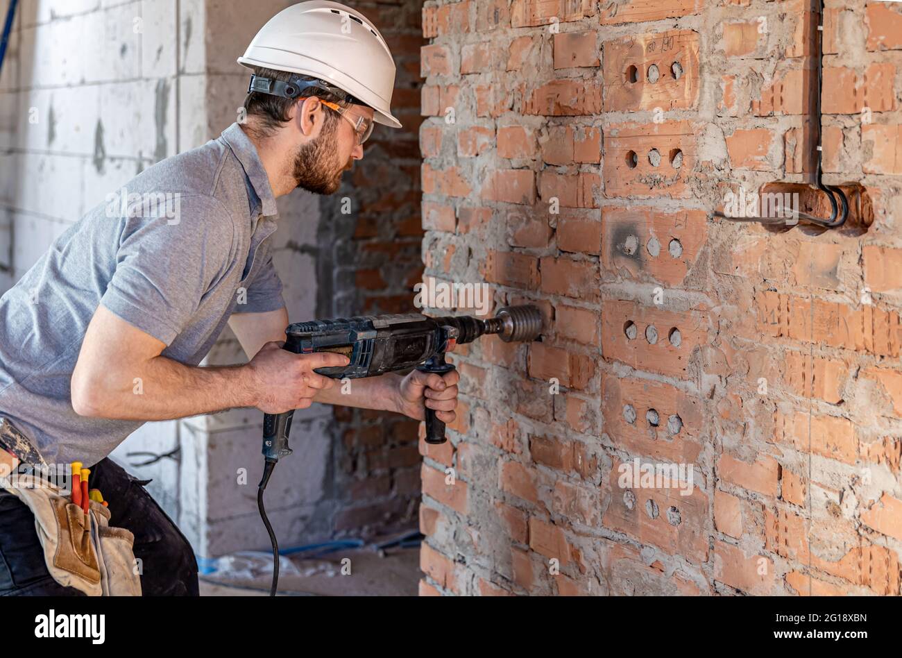 Close-up of the process of drilling a brick wall at a construction site ...