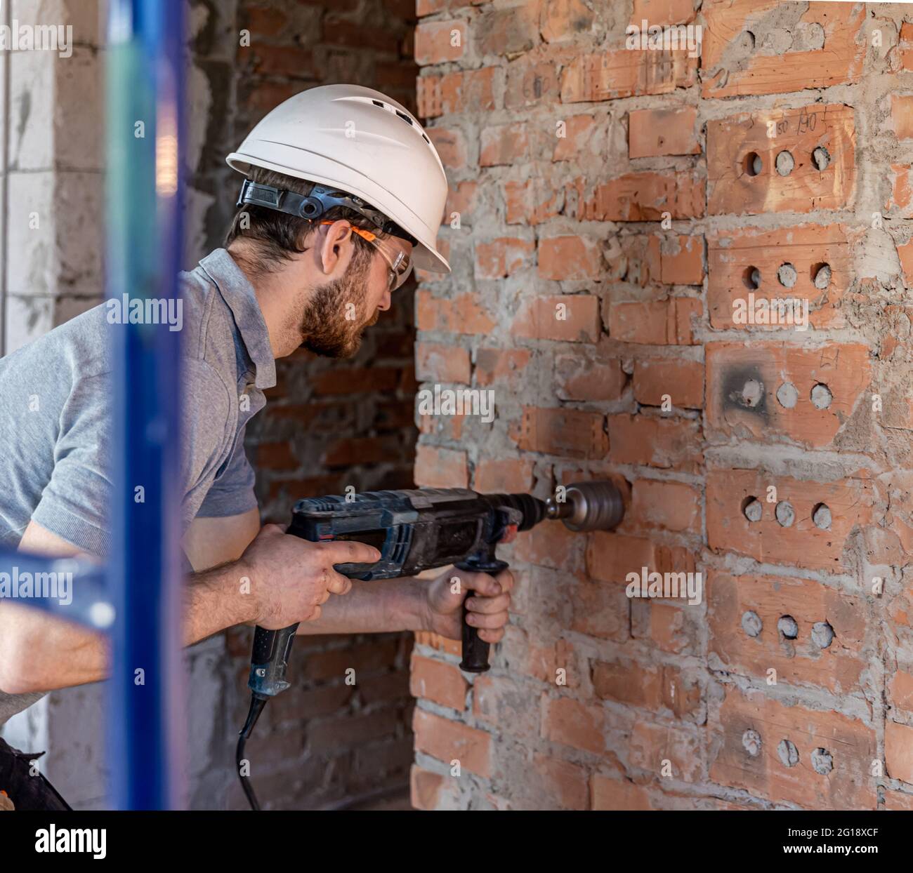 Close-up of the process of drilling a brick wall at a construction site ...
