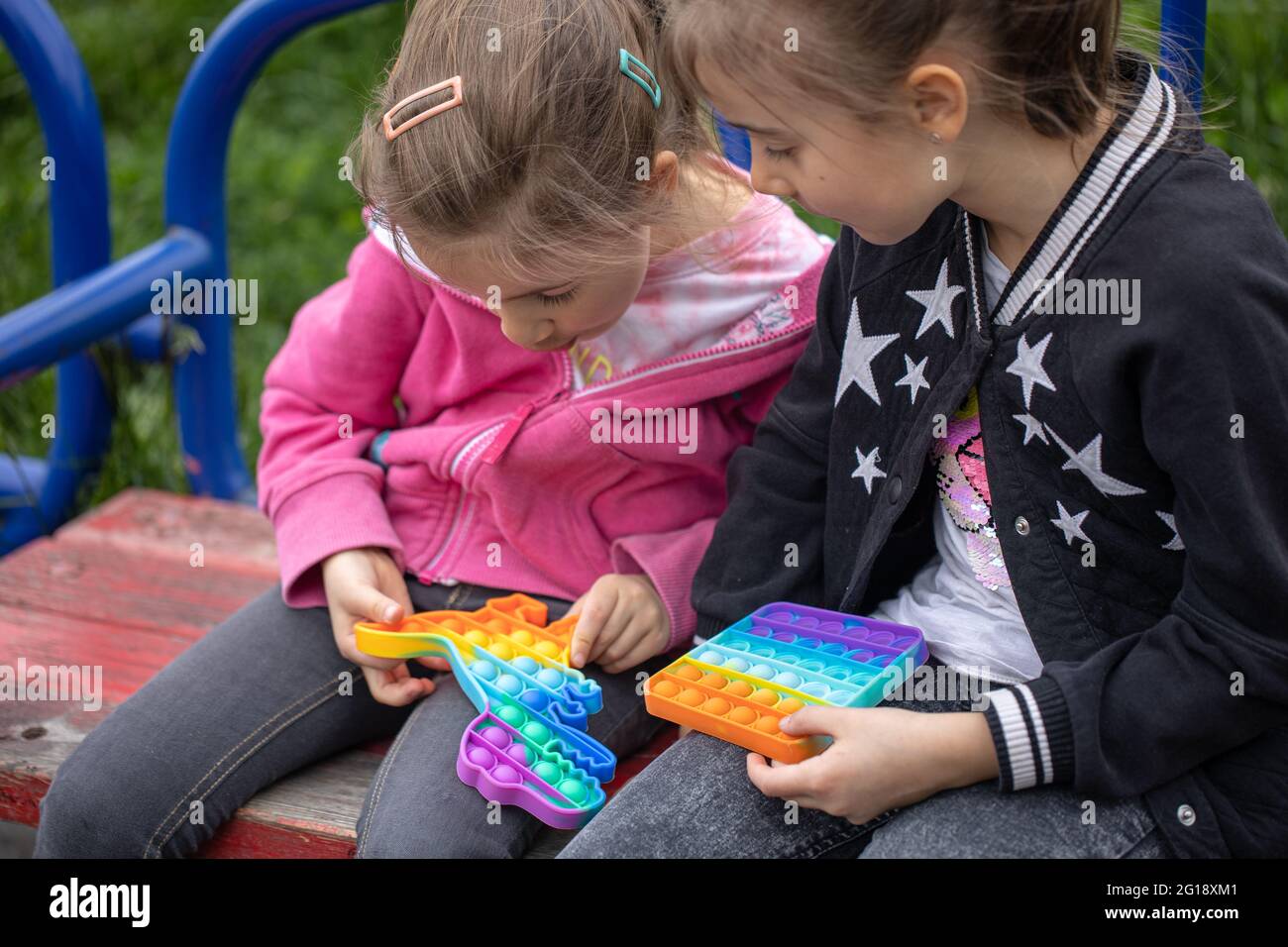 Little girls playing a new fidget toy popular with children helps them ...