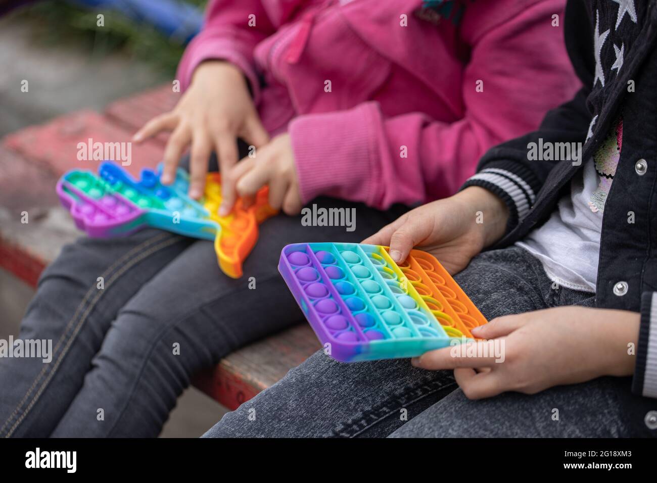 Little girls playing a new fidget toy popular with children helps them ...