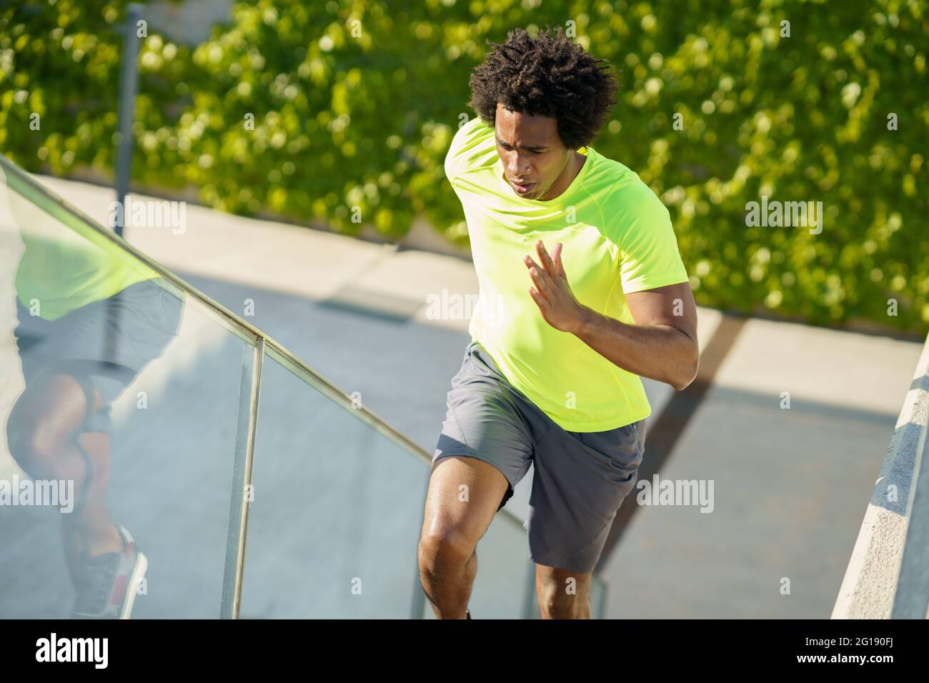 Black man running upstairs outdoors. Young male exercising Stock Photo ...