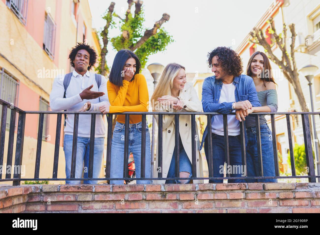 Multiracial group of young people talking together in the street Stock ...