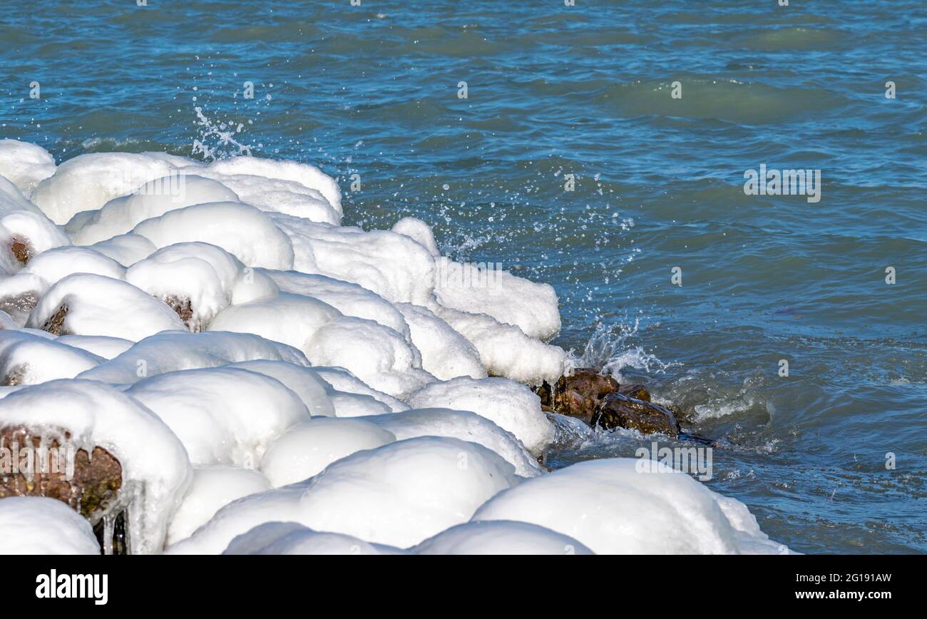 A snowy beach and sea splash Stock Photo - Alamy