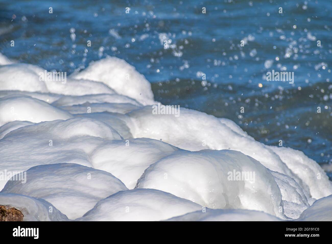 A snowy beach and sea splash Stock Photo - Alamy