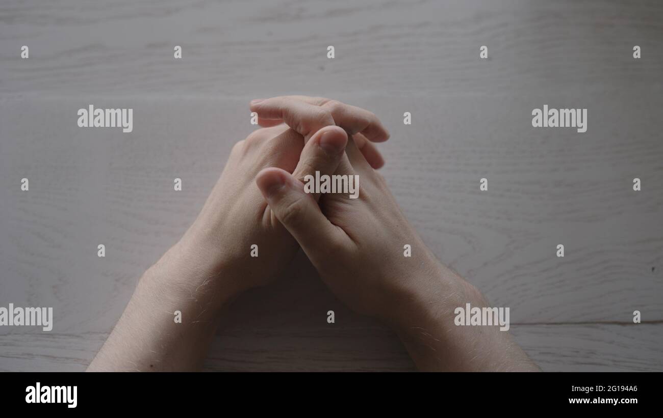 man hands on white oak table with window light while waiting, real time ...