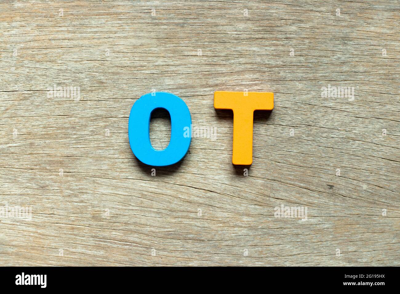 Color alphabet letter in word OT (abbreviation for overtime) on wood ...