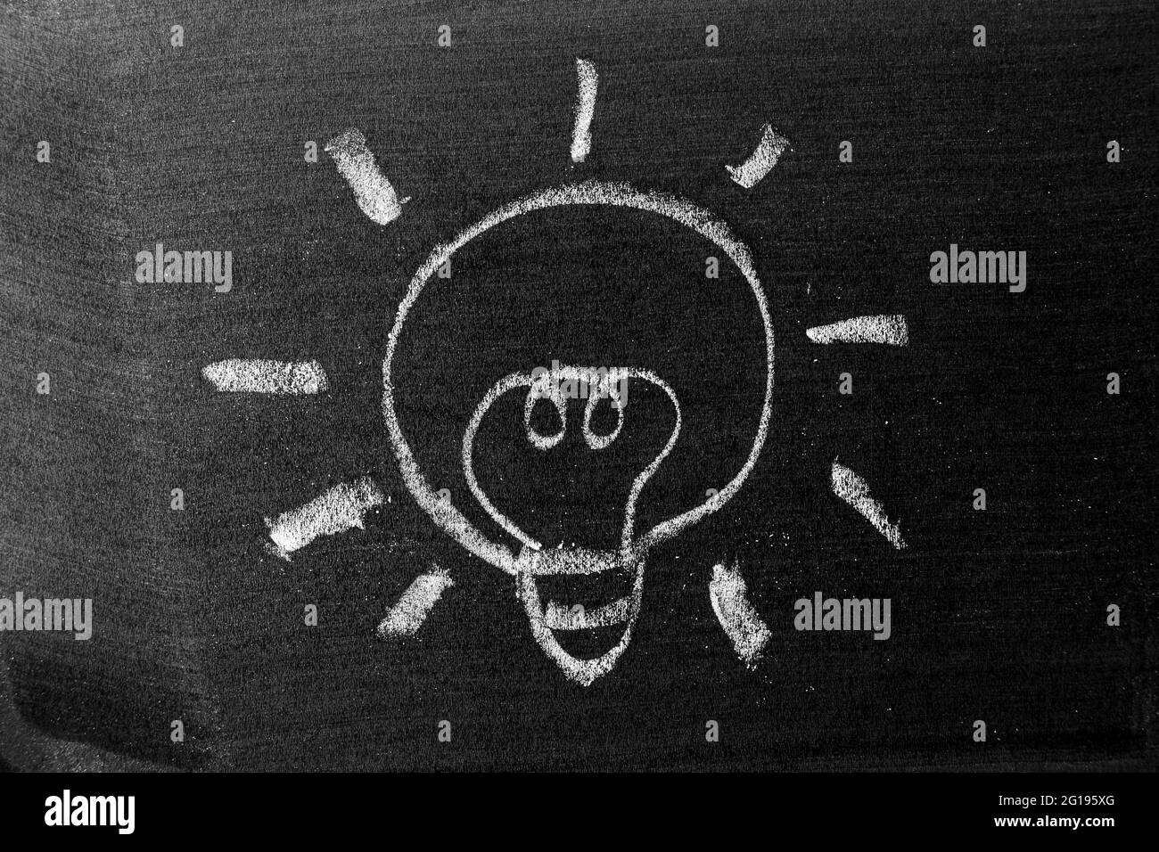 White chalk hand drawing in light bulb shape on blackboard or ...