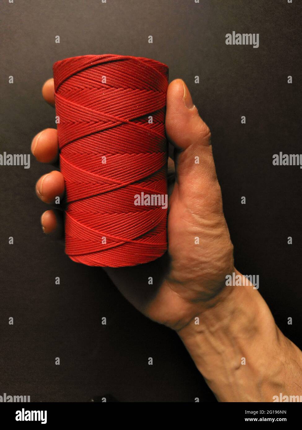 A vertical top view of red sewing thread on a person's hand Stock Photo ...