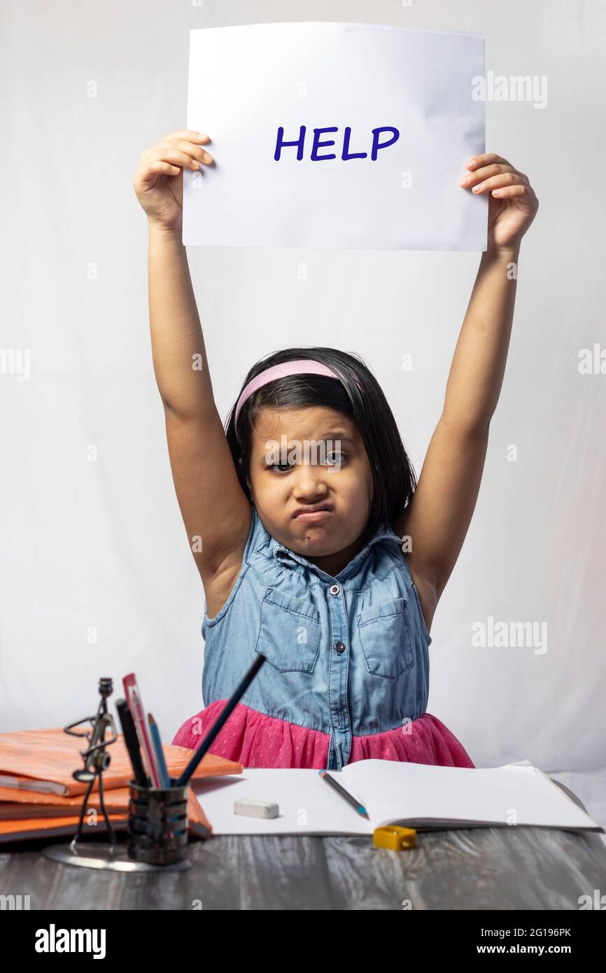 A unhappy Indian girl child holding a blank sheet of paper over her ...