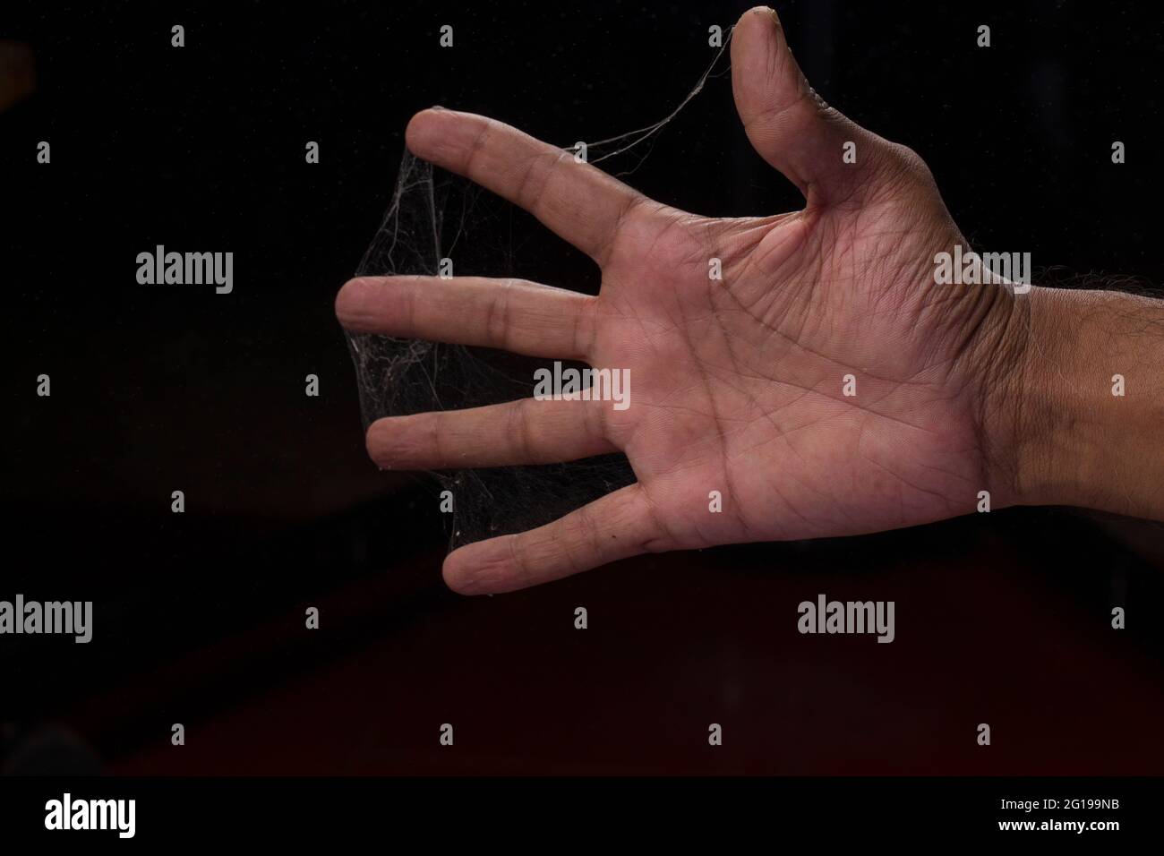 A man fingers covered with spider web on black background Stock Photo ...