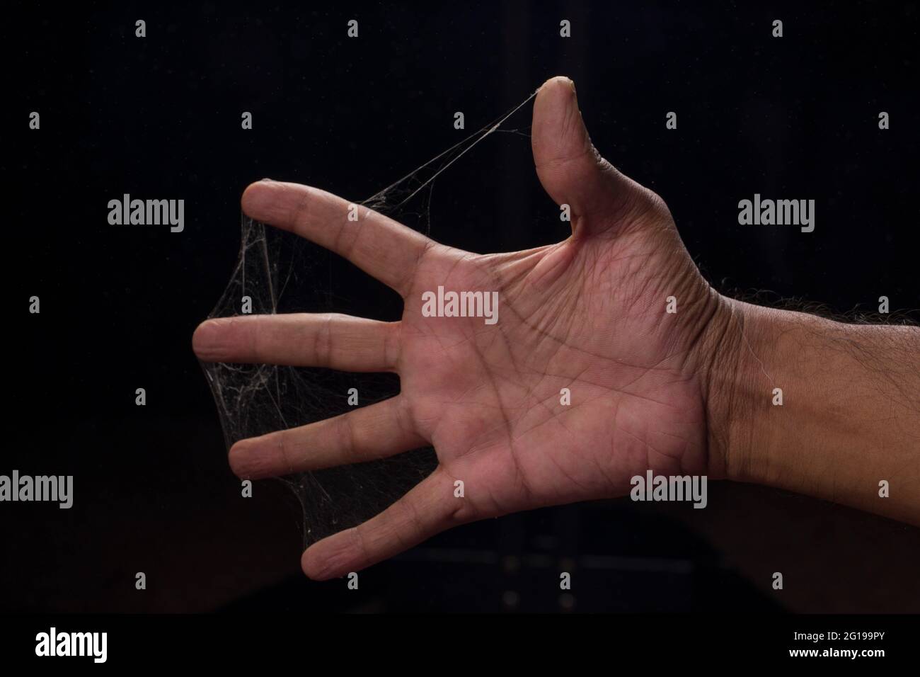 A man fingers covered with spider web on black background Stock Photo ...
