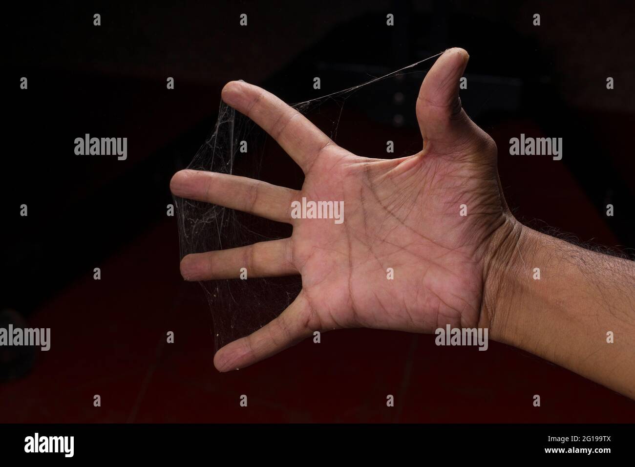 A man fingers covered with spider web on black background Stock Photo ...