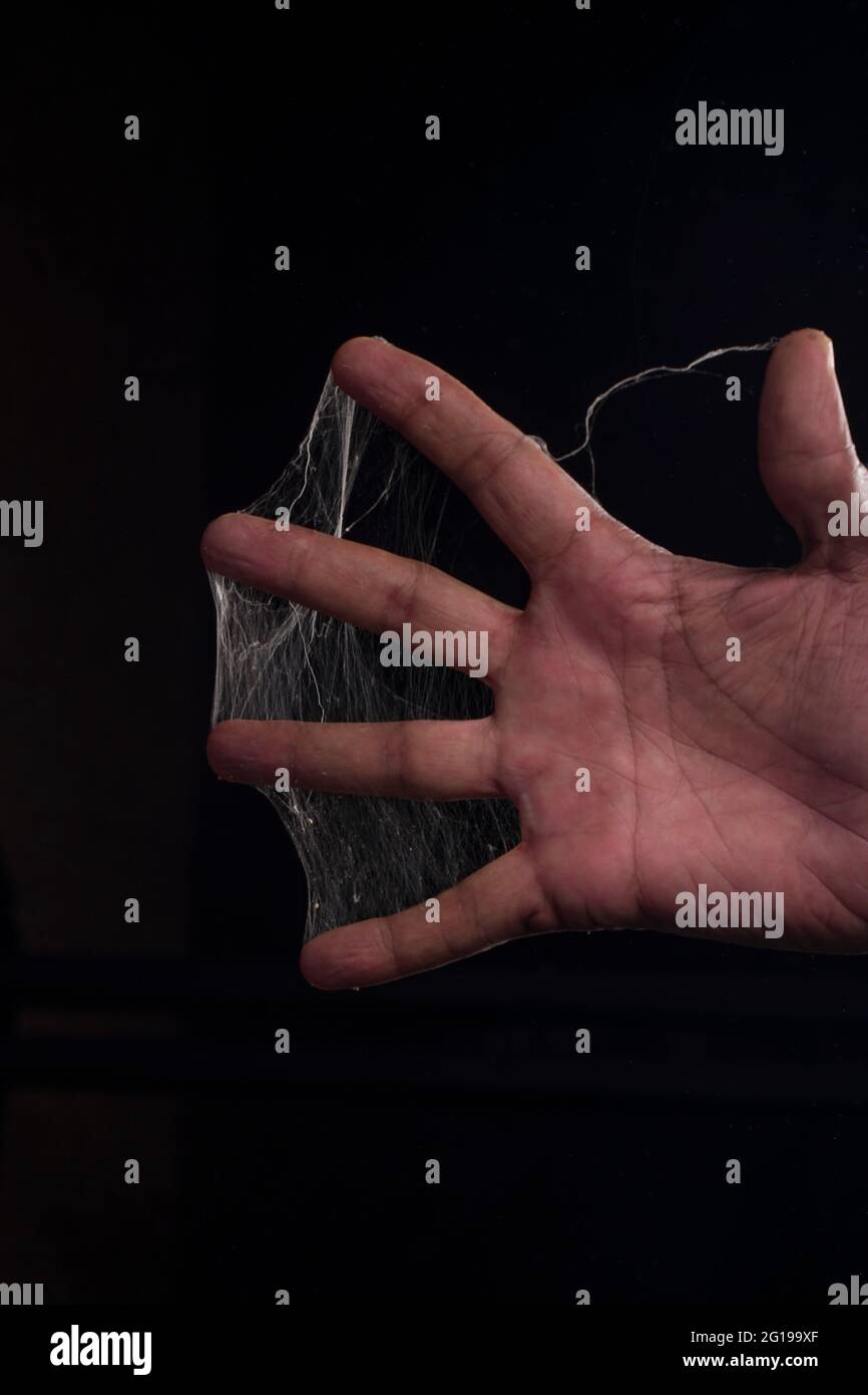 A man fingers covered with spider web on black background Stock Photo ...