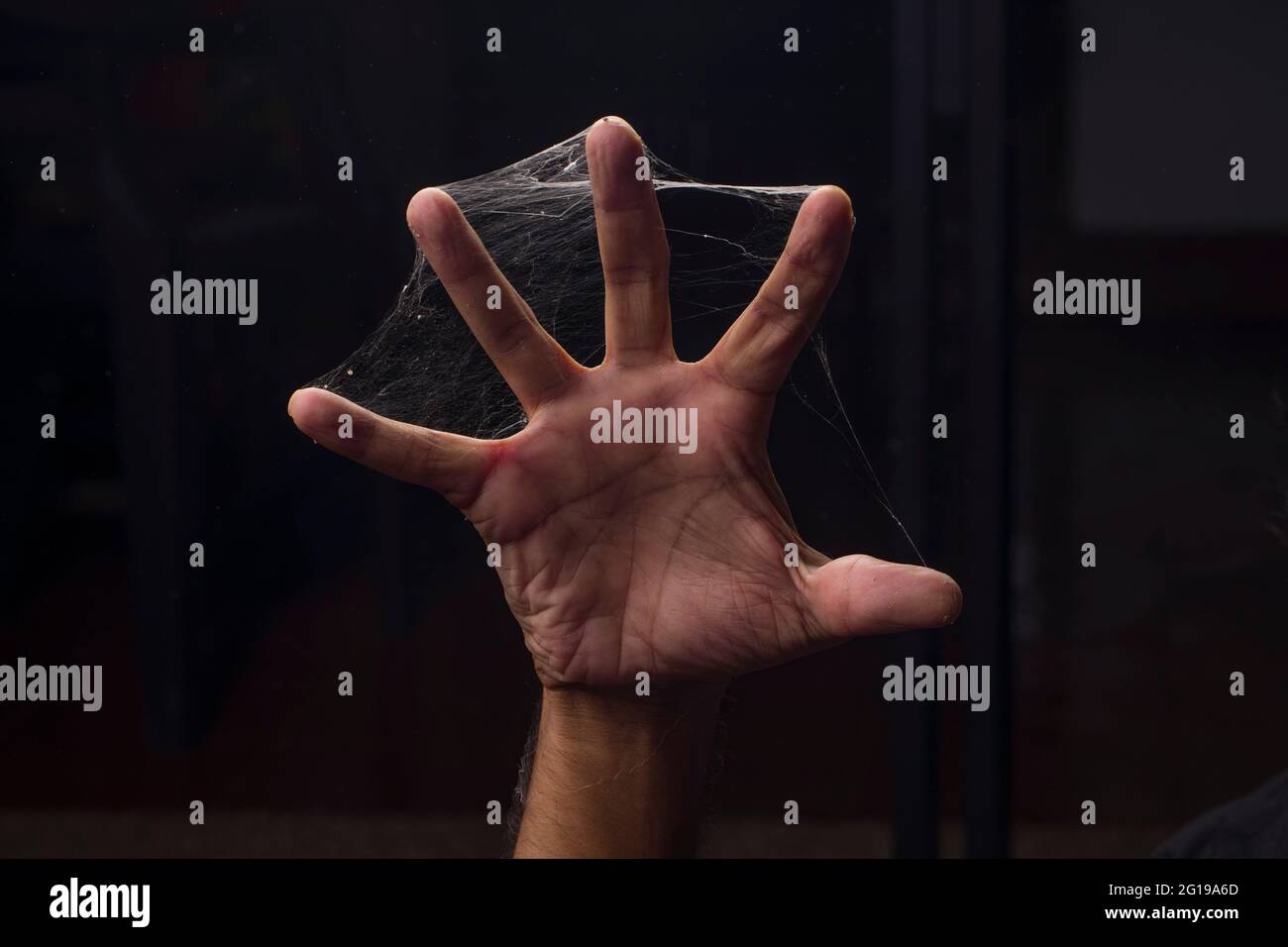 A man fingers covered with spider web on black background Stock Photo ...