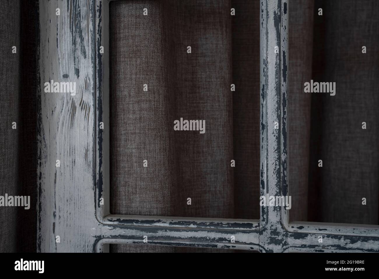 Vintage wooden window with fading white paint on a dark background ...