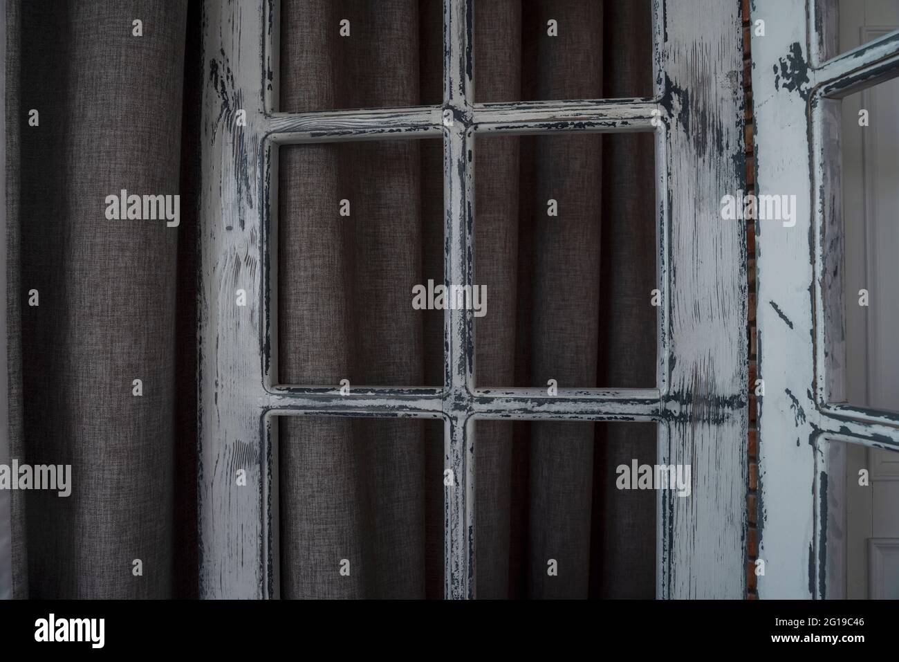 Vintage wooden window with fading white paint on a dark background ...