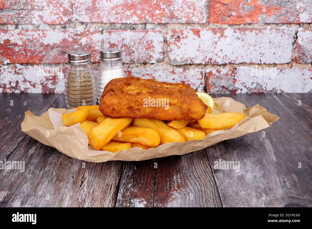 Battered cod fish and chips meal wrapped in brown paper Stock Photo - Alamy