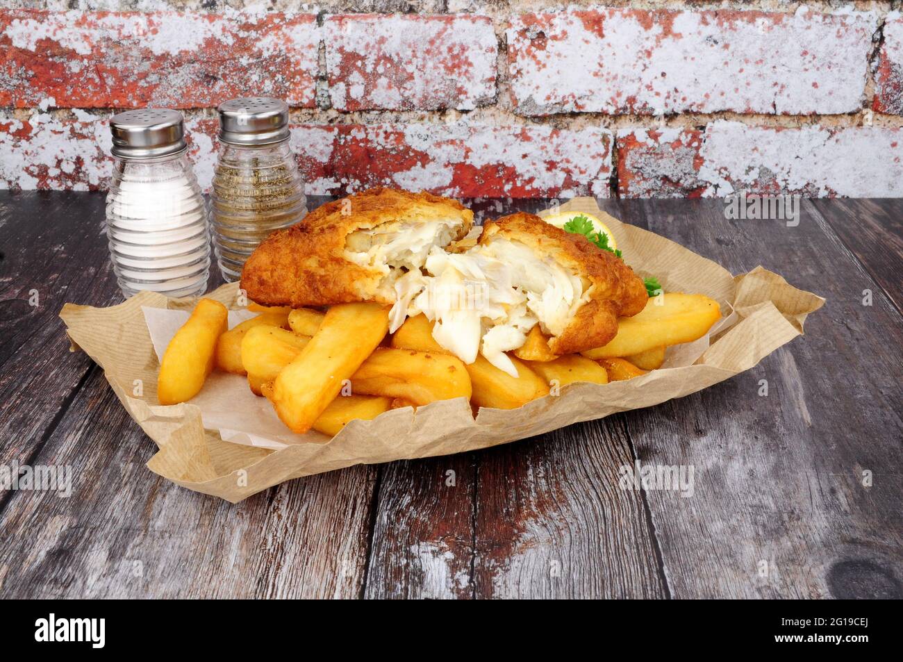 Battered cod fish and chips meal wrapped in brown paper Stock Photo - Alamy