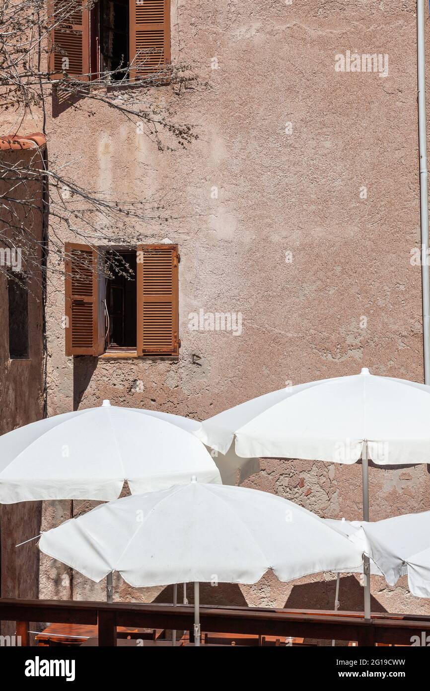 Three white parasols grouped together against a background of a gray ...