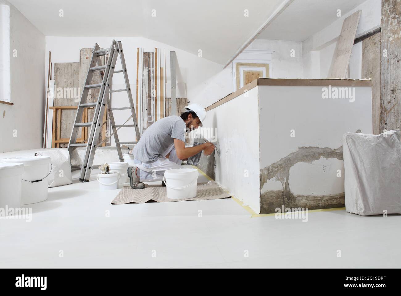 plasterer man at work, take the mortar from the bucket with trowel to ...