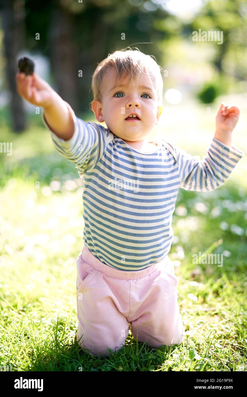 Kid kneeling in the grass hi-res stock photography and images - Alamy