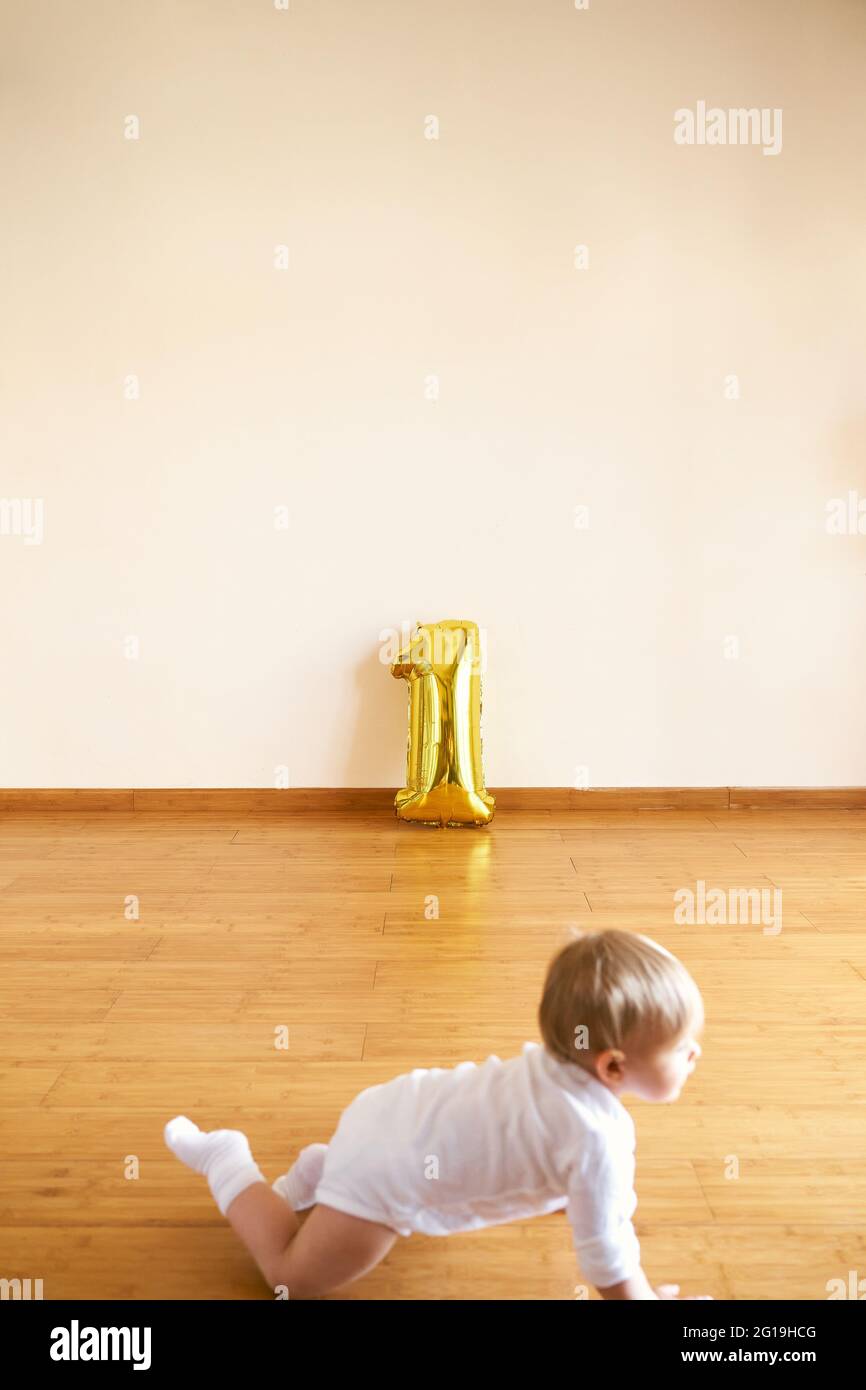 Little girl crawling on the floor against the background of an ...