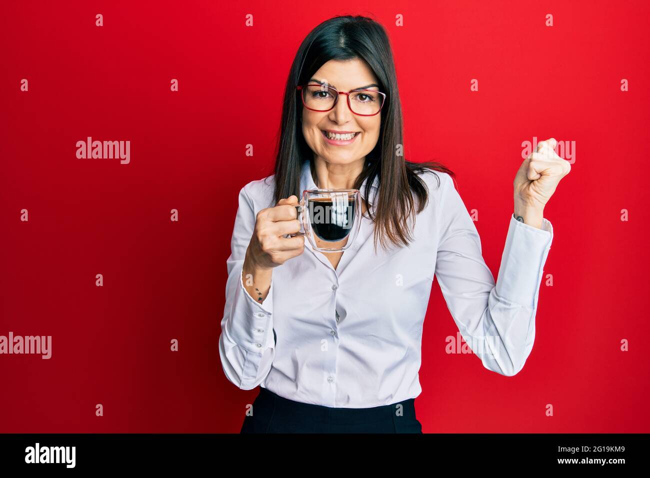 Young hispanic woman wearing business style drinking cup of coffee ...