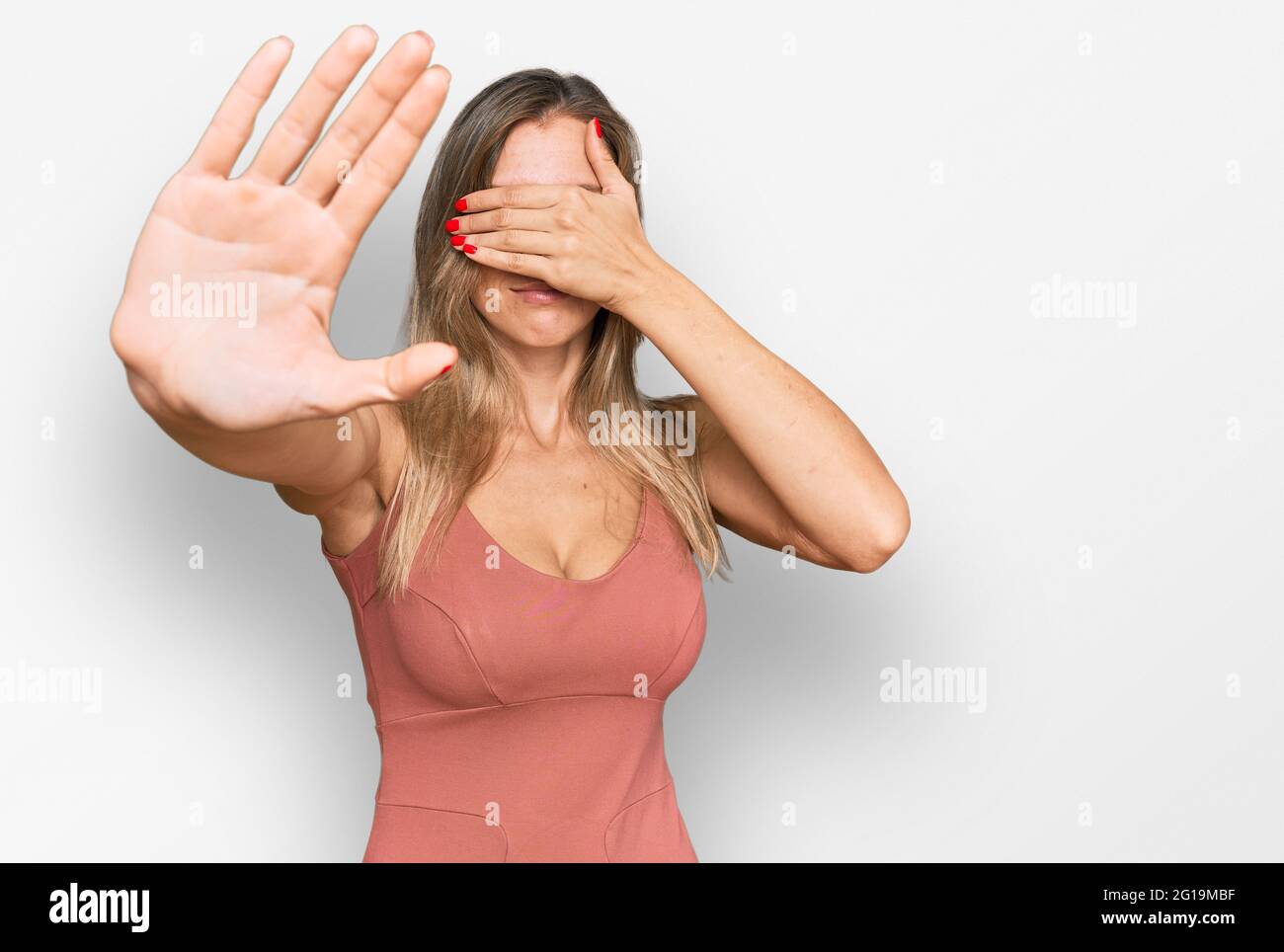 Beautiful caucasian woman wearing casual clothes covering eyes with ...