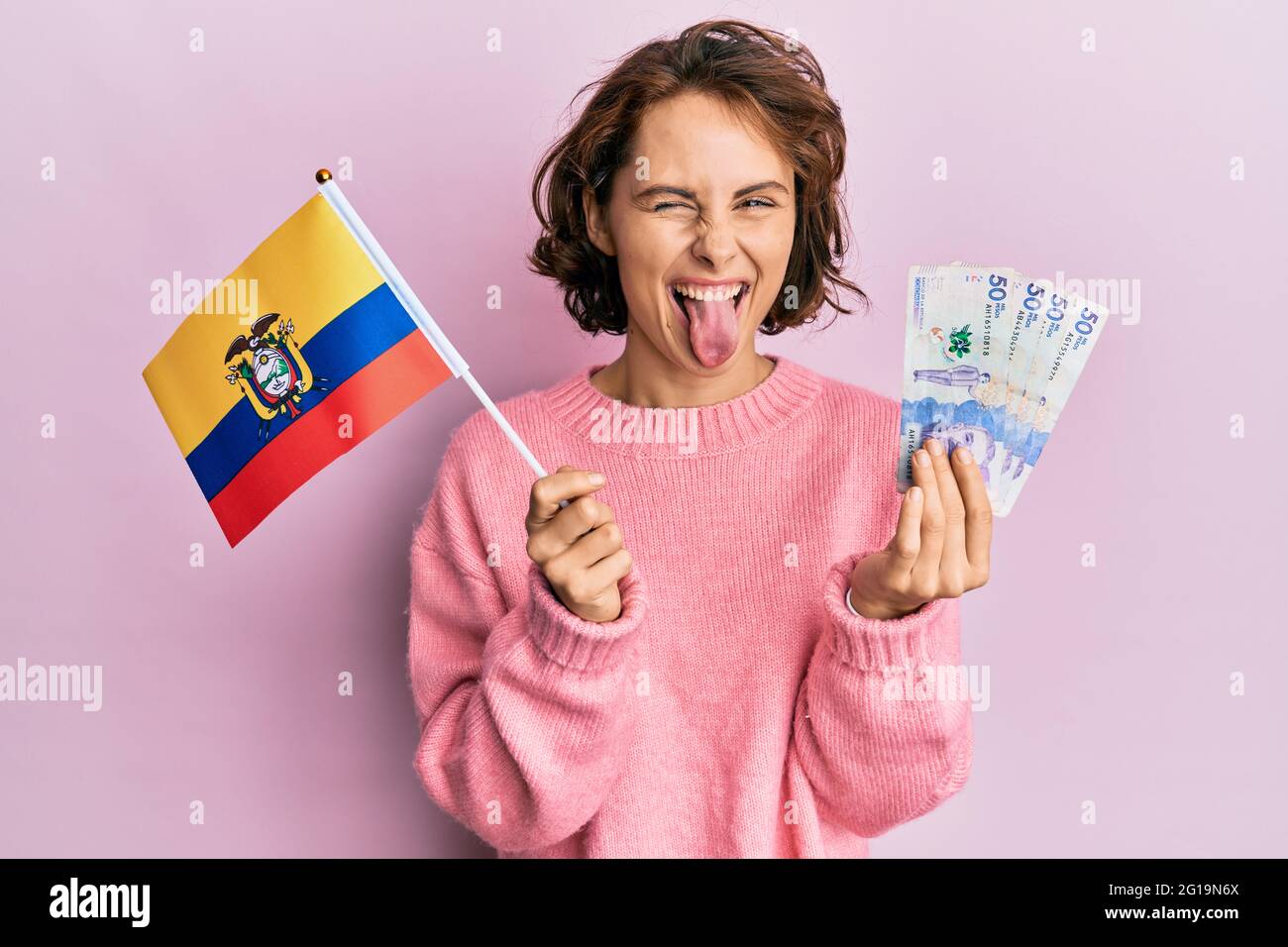 Young brunette woman holding colombia flag and colombian pesos ...
