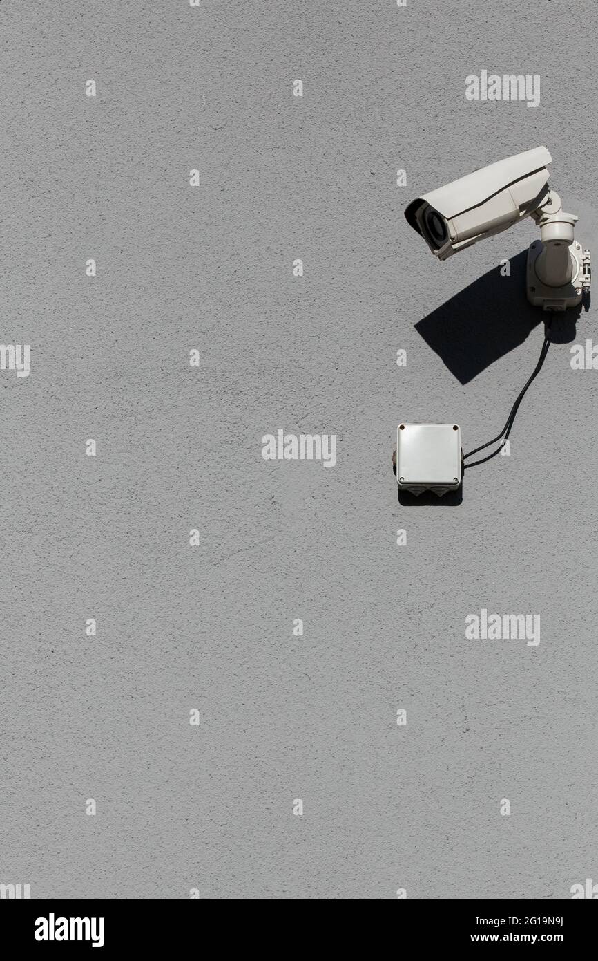 small white surveillance camera on flat gray matte plaster wall Stock ...