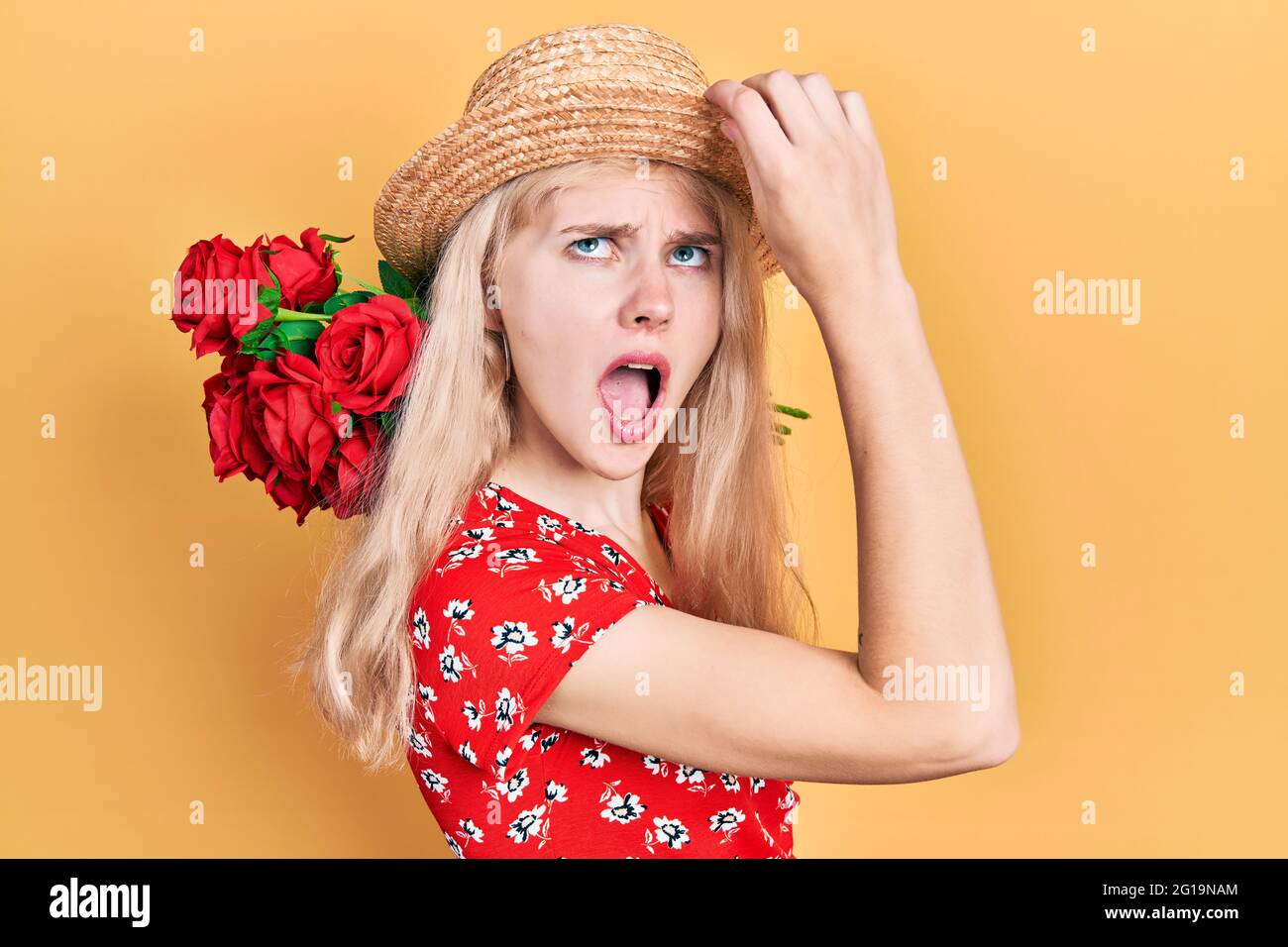 Beautiful caucasian woman with blond hair holding bouquet of red roses ...