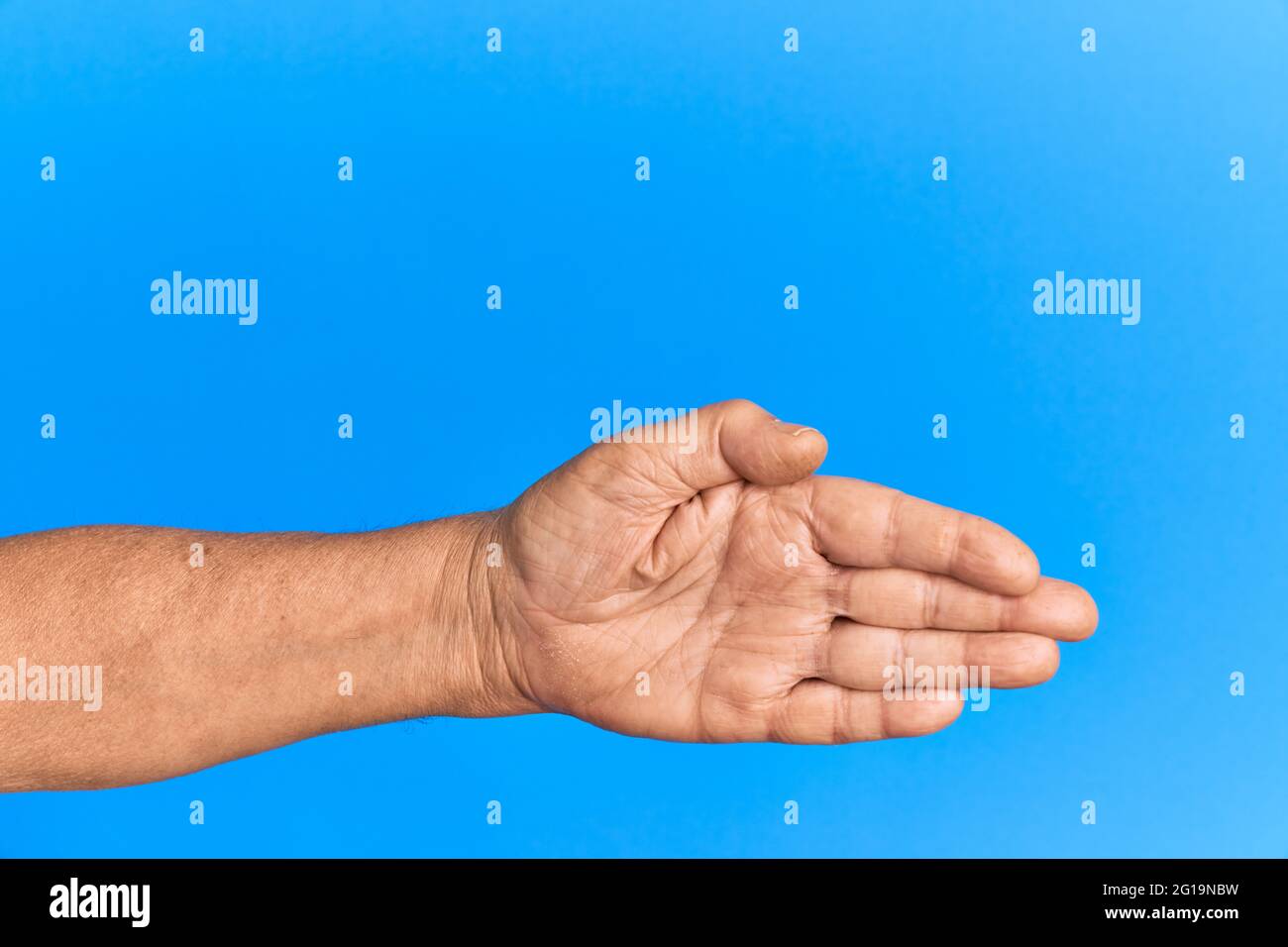 Hand of senior hispanic man over blue isolated background stretching ...