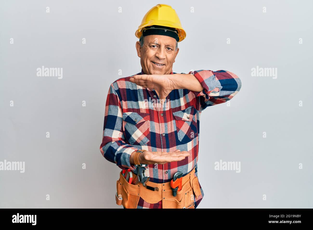 Senior hispanic man wearing handyman uniform gesturing with hands ...