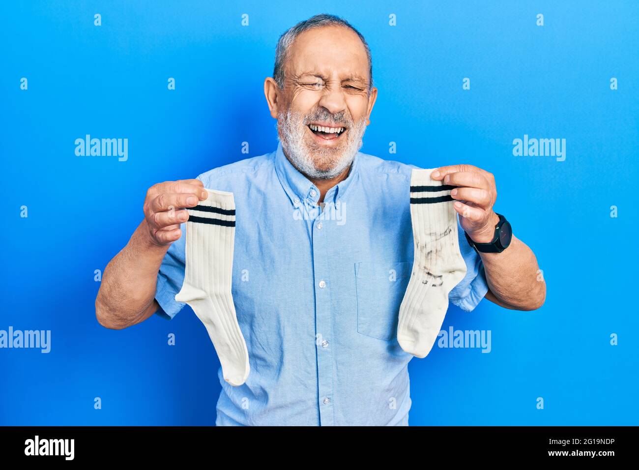 Handsome senior man with beard holding clean andy dirty socks smiling ...