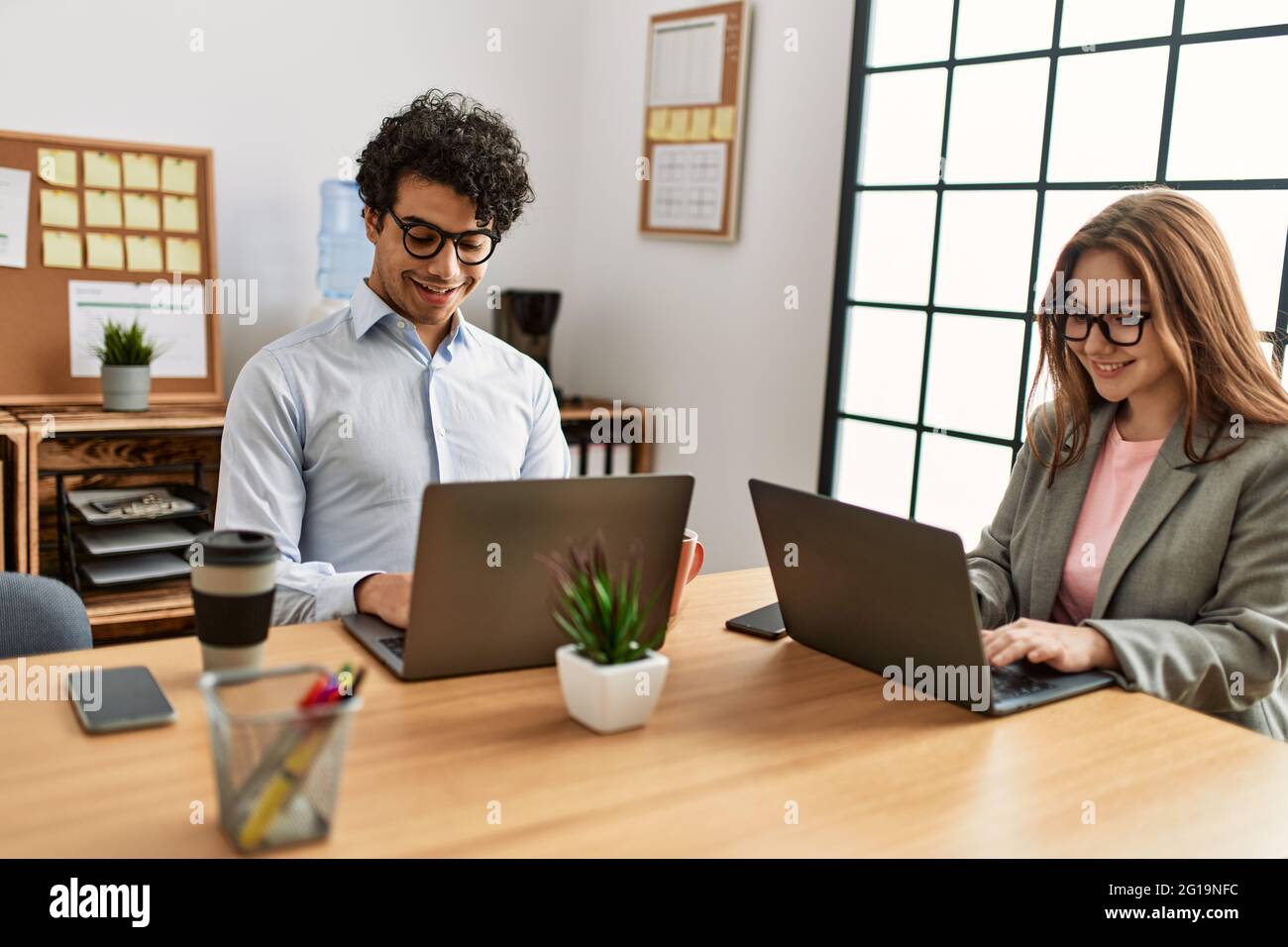 Two business workers smiling happy working at the office Stock Photo ...