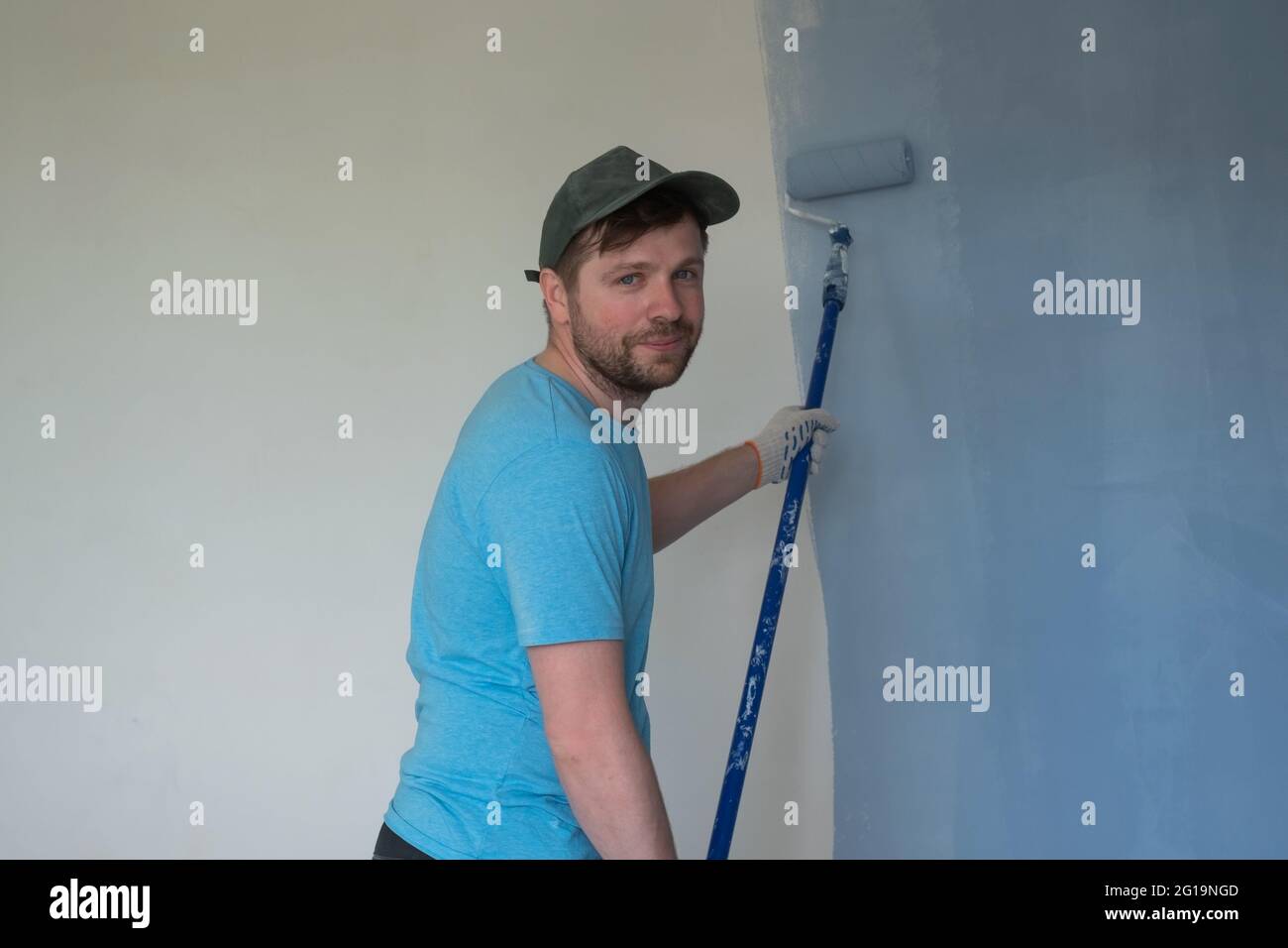 Worker painting walls with a roller during flat renovation Stock Photo ...