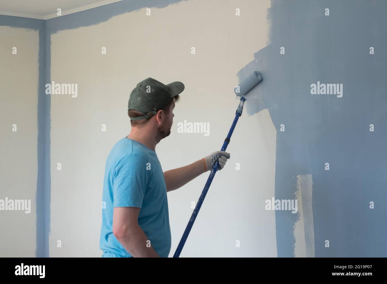Worker painting walls with a roller during flat renovation Stock Photo ...