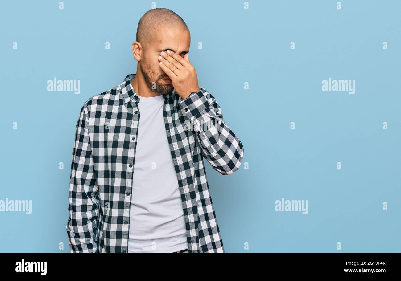 Hispanic adult man wearing casual clothes tired rubbing nose and eyes ...