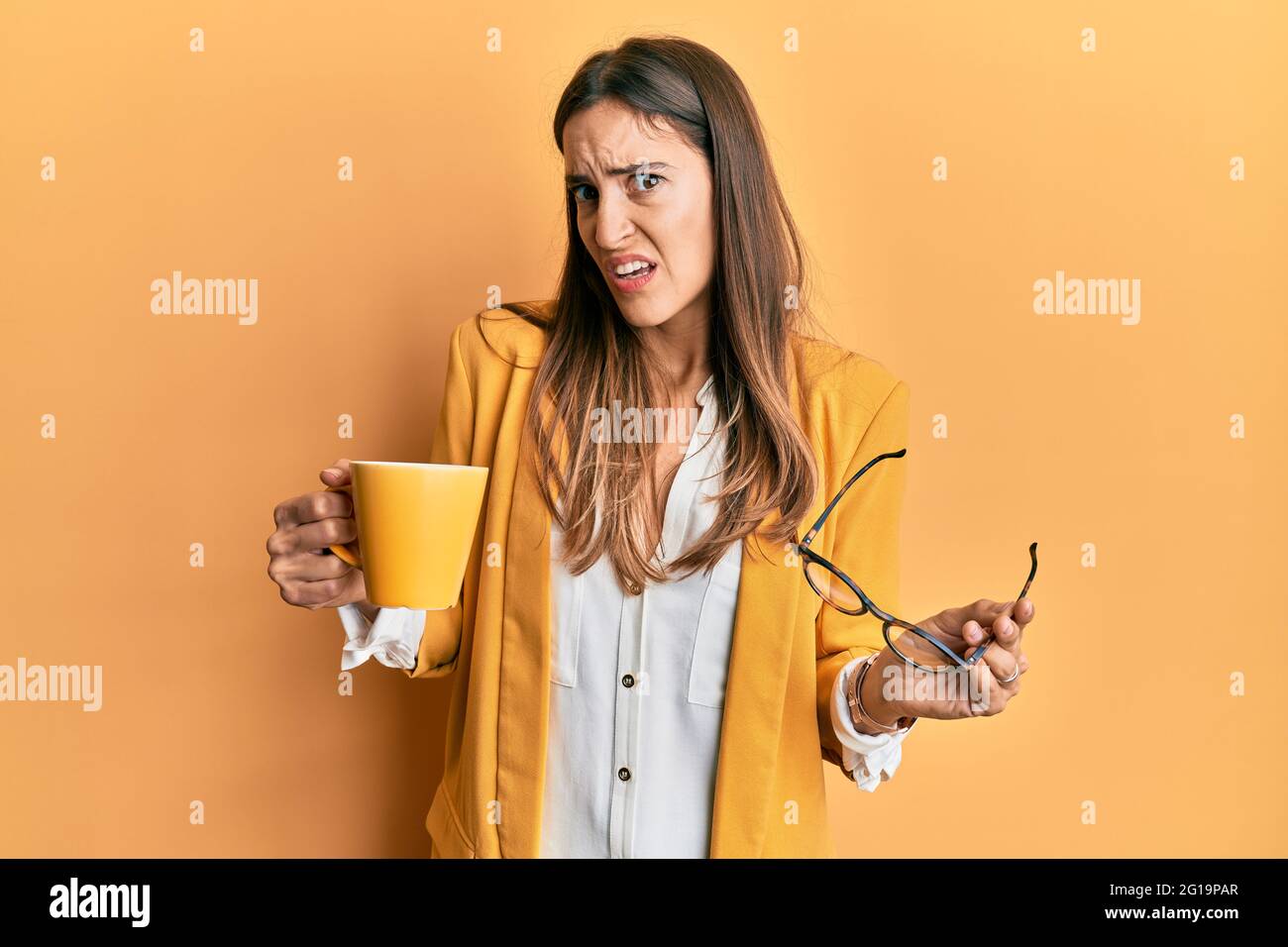 Young beautiful woman wearing business style drinking cup of coffee ...
