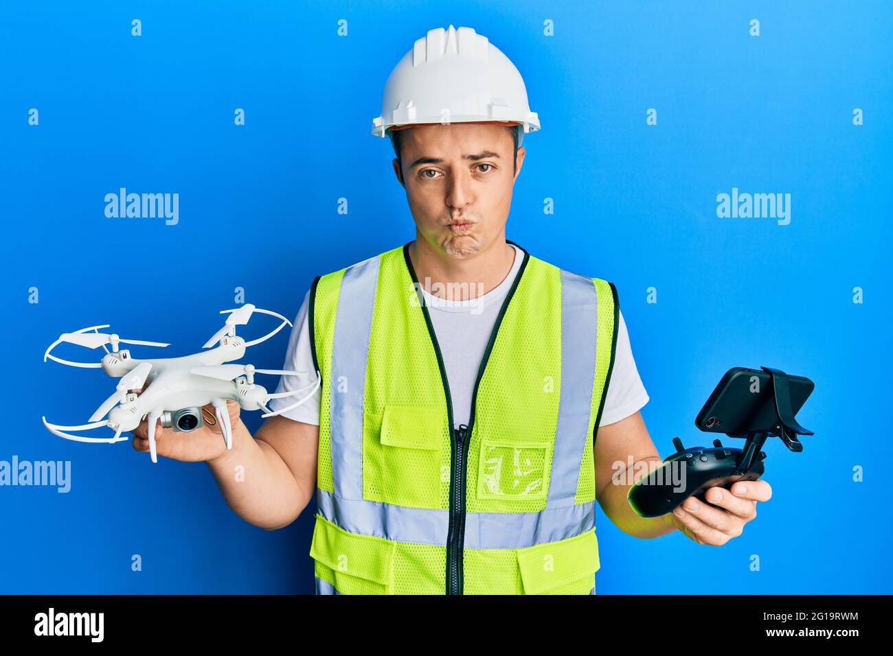 Handsome young man wearing safety hard using drone and control ...