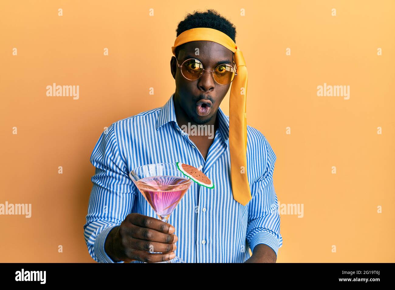 Handsome black man drunk wearing tie over head and sunglasses drinking ...