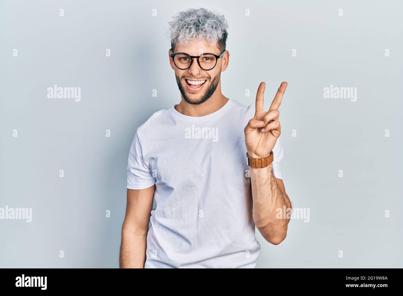 Young hispanic man with modern dyed hair wearing white t shirt and ...