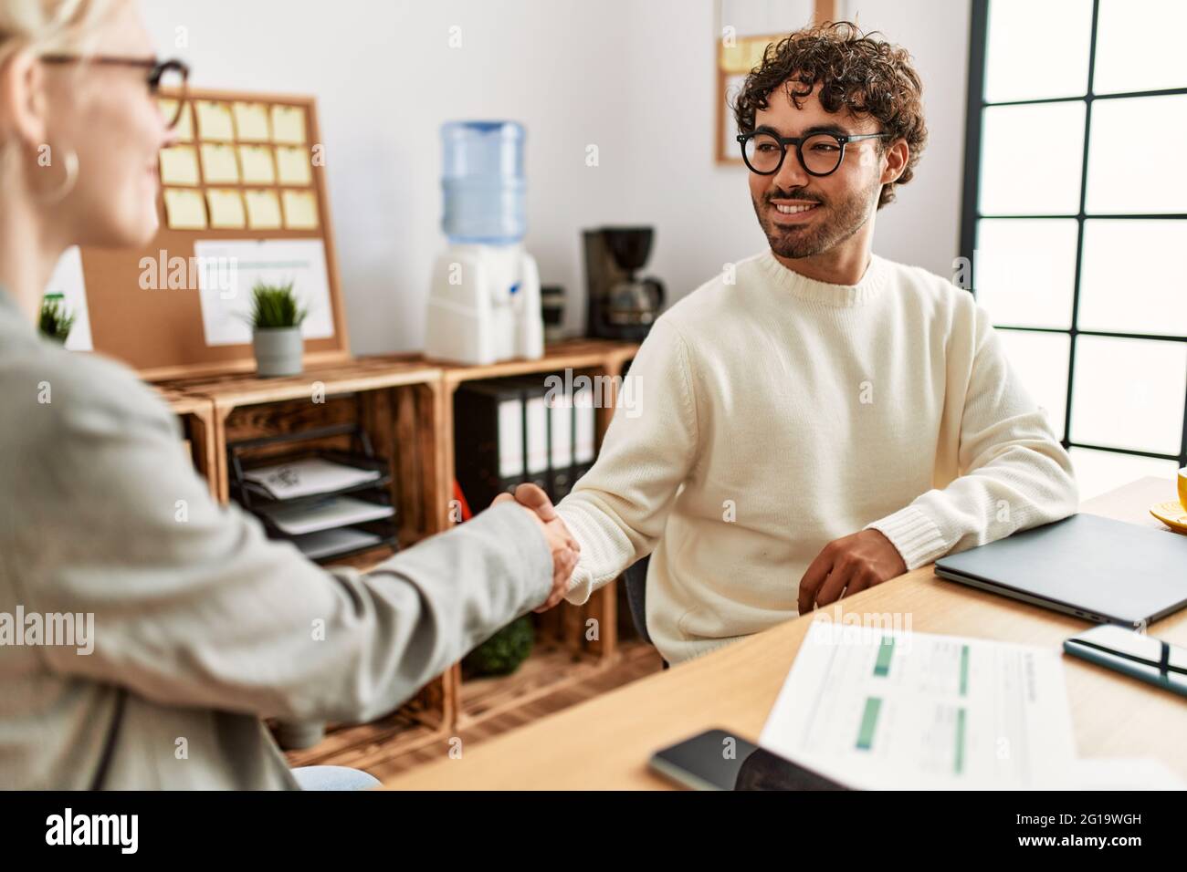 Two business workers shaking hands at the office Stock Photo - Alamy