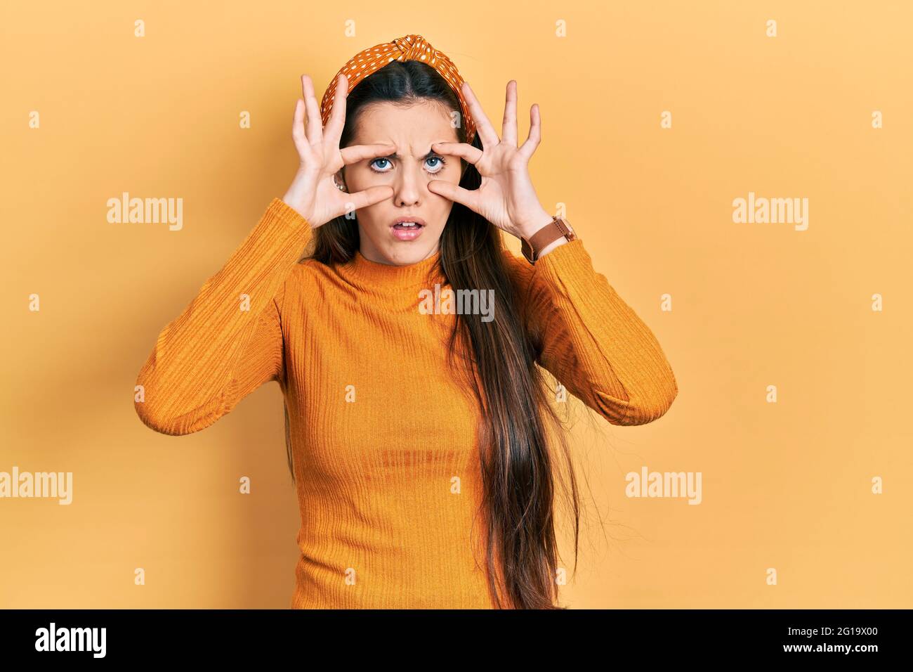 Young brunette teenager wearing casual yellow sweater trying to open ...