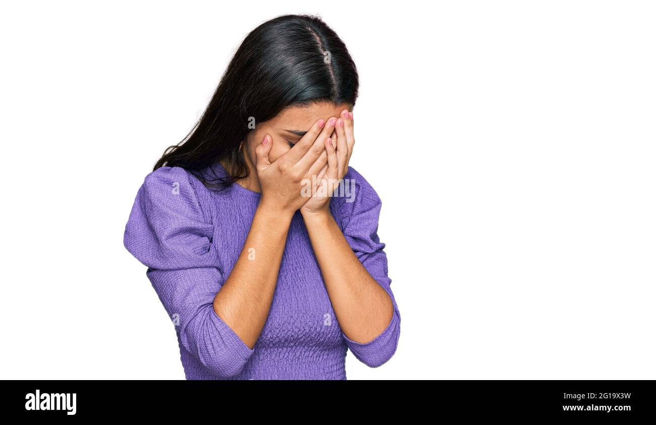 Young hispanic girl wearing casual clothes with sad expression covering ...