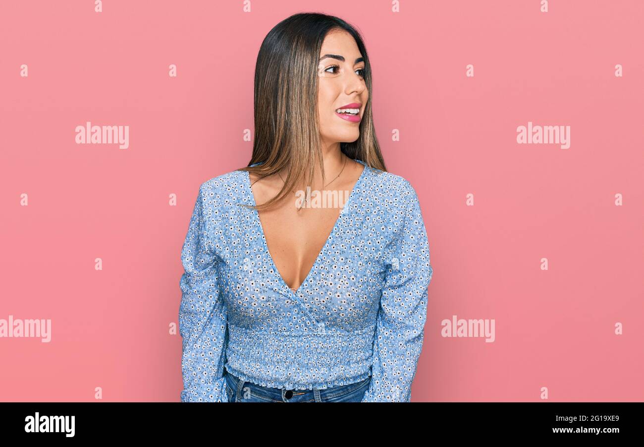 Young hispanic woman wearing casual clothes looking away to side with ...